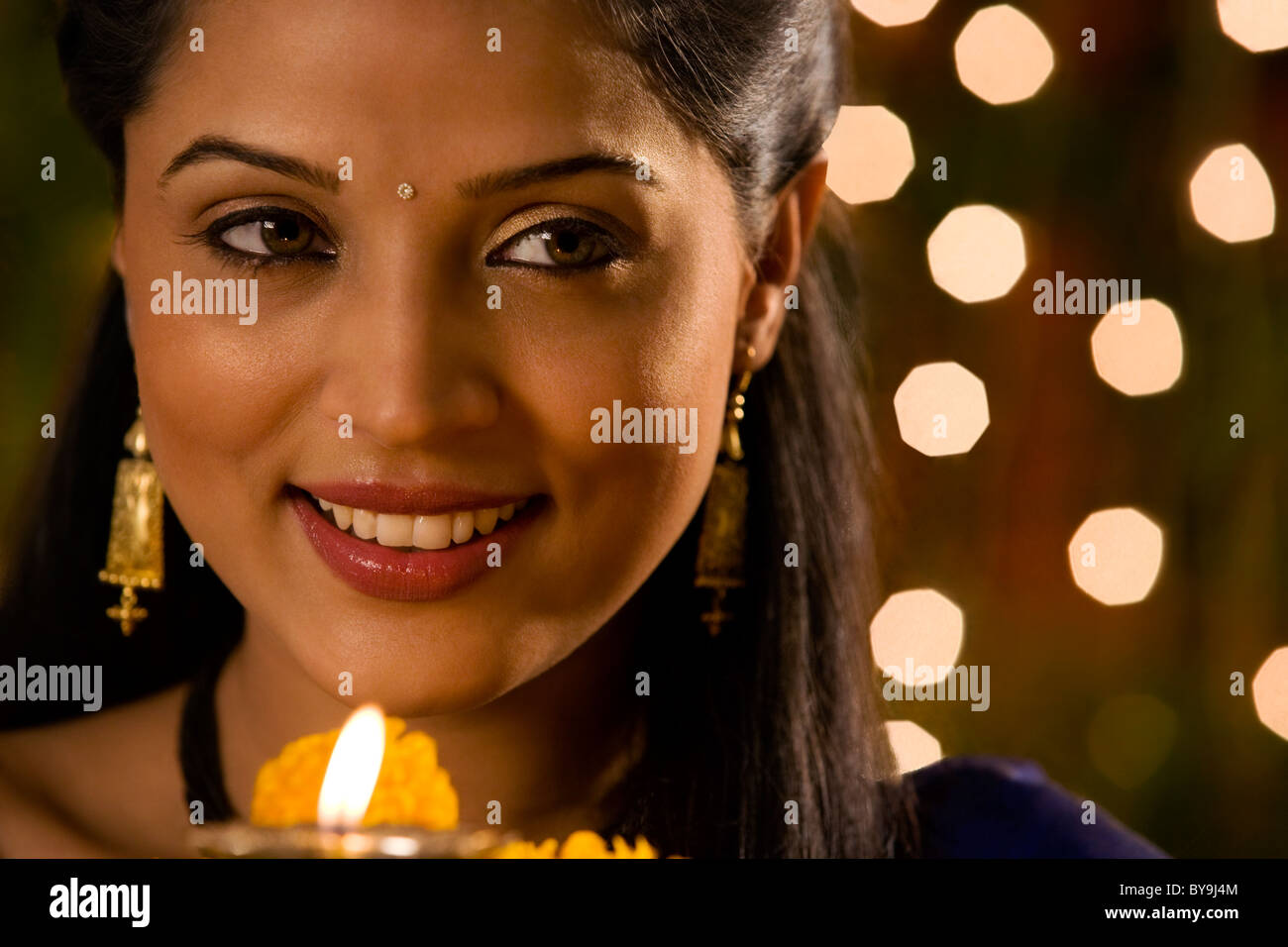 Traditional indian woman lighting diya hi-res stock photography and ...