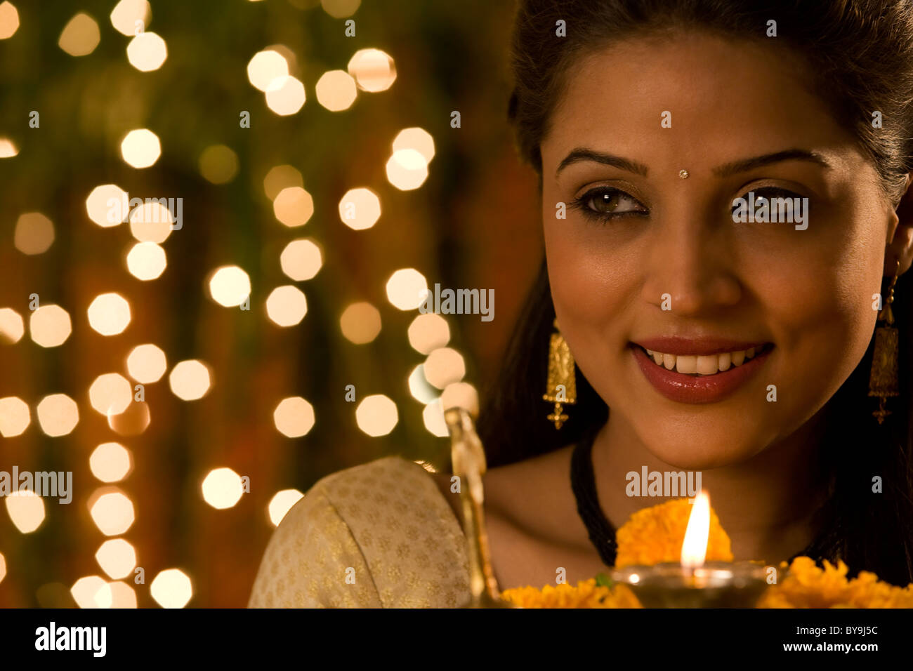 Women lighting diya hi-res stock photography and images - Alamy