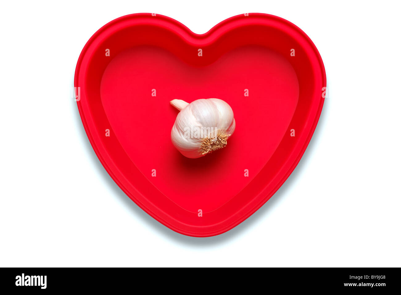 Conceptual photo of a whole garlic in a heart shaped dish to represent ...