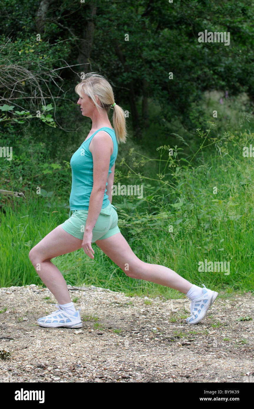 Woman exercising legs and body with stretching movements in the ...