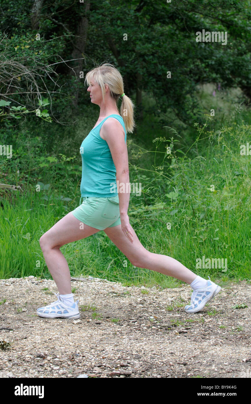 Woman exercising legs and body with stretching movements in the ...