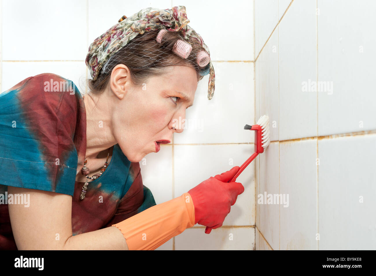 funny angry woman using brush to wash shower tiles Stock Photo - Alamy