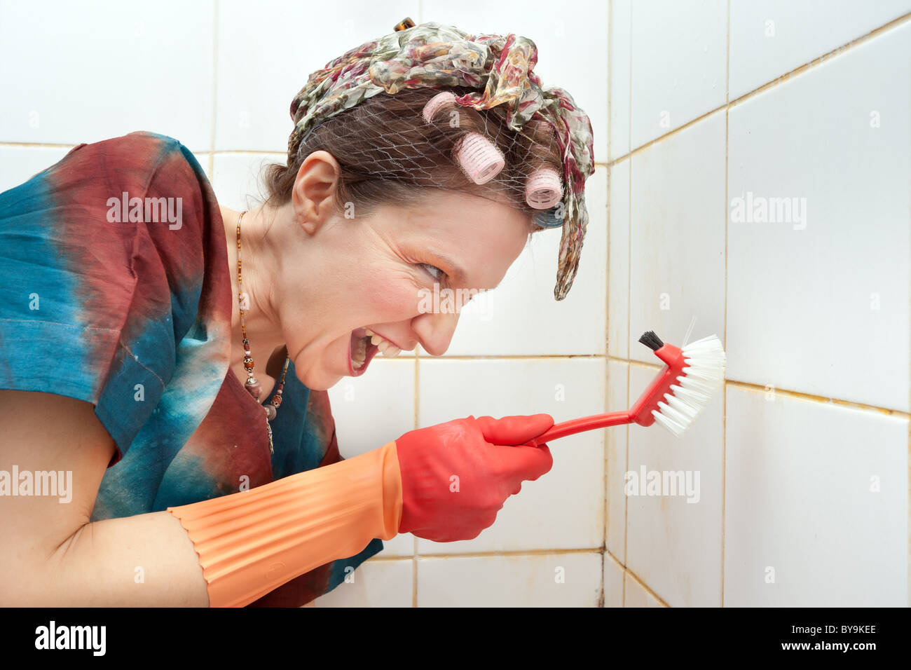 funny angry woman using brush to wash shower tiles Stock Photo - Alamy
