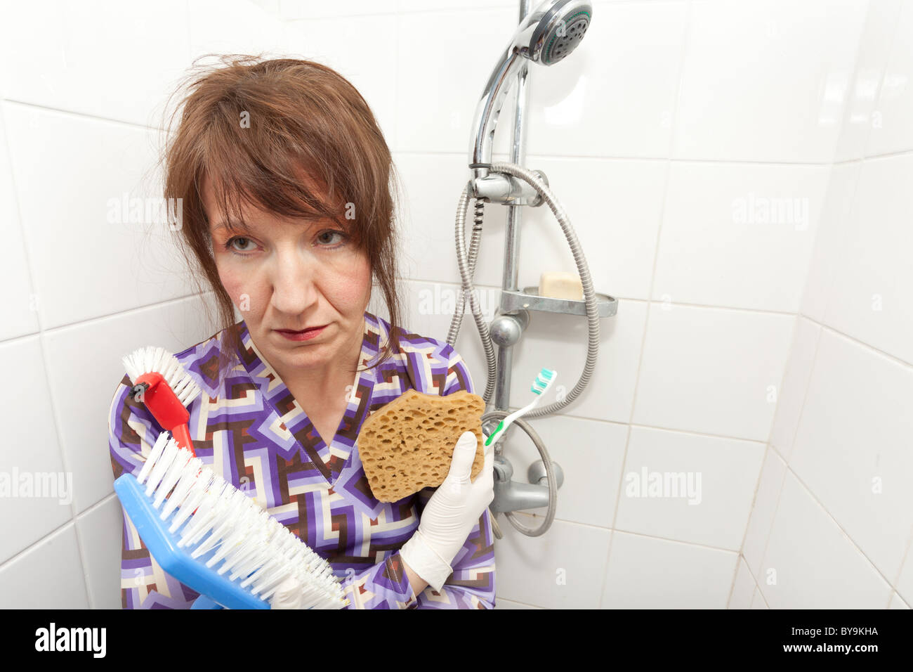 woman holding brushes very bored to clean bathroom shower Stock Photo ...