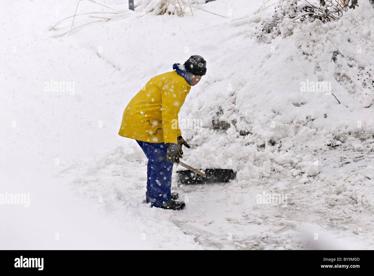 Man with snow shovel in snowstorm Stock Photo - Alamy