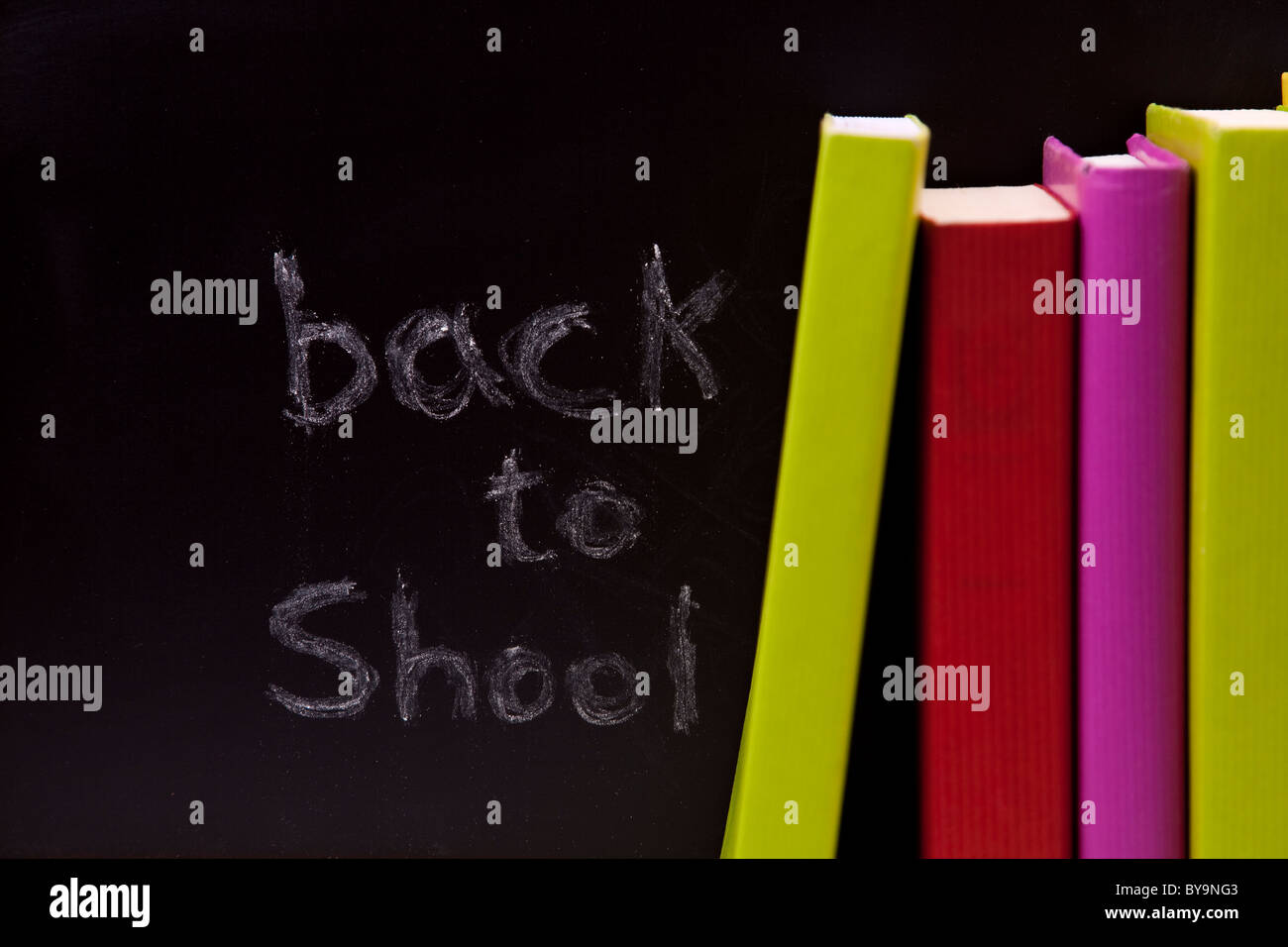 Back to school letters written on a blackboard with colorful books ...