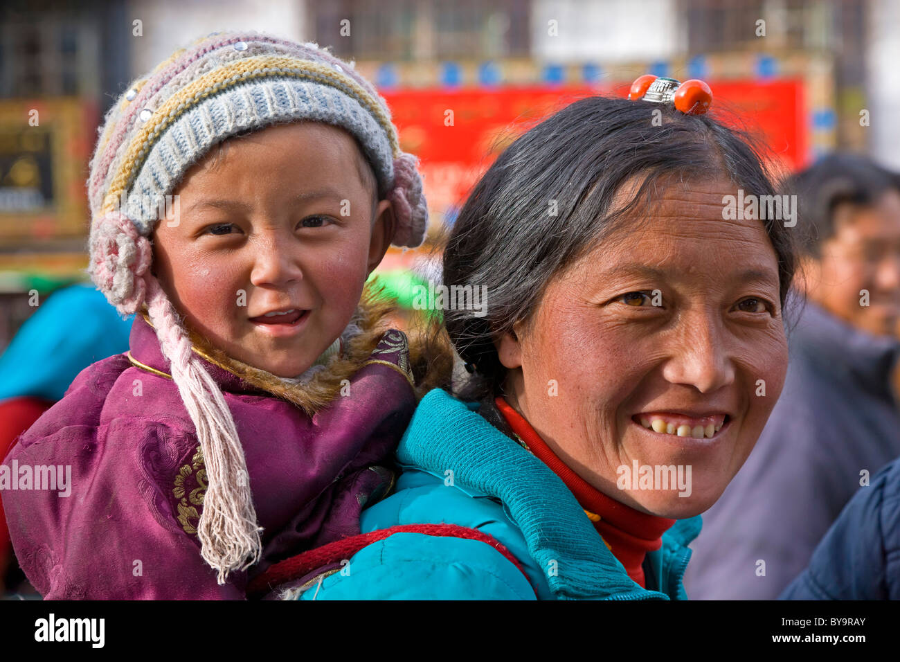 Smiling Tibetan woman mother and child in papoose on her back in the ...