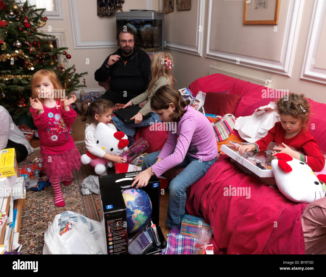 Family On Christmas Day Opening Presents Around The Christmas Tree ...
