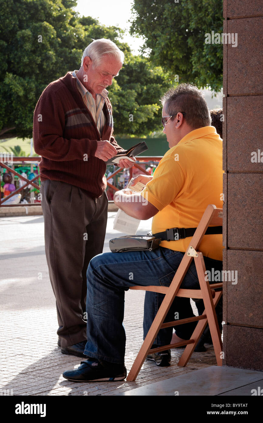 A man buys an ONCE lottery ticket from a vendor at the door of the ...