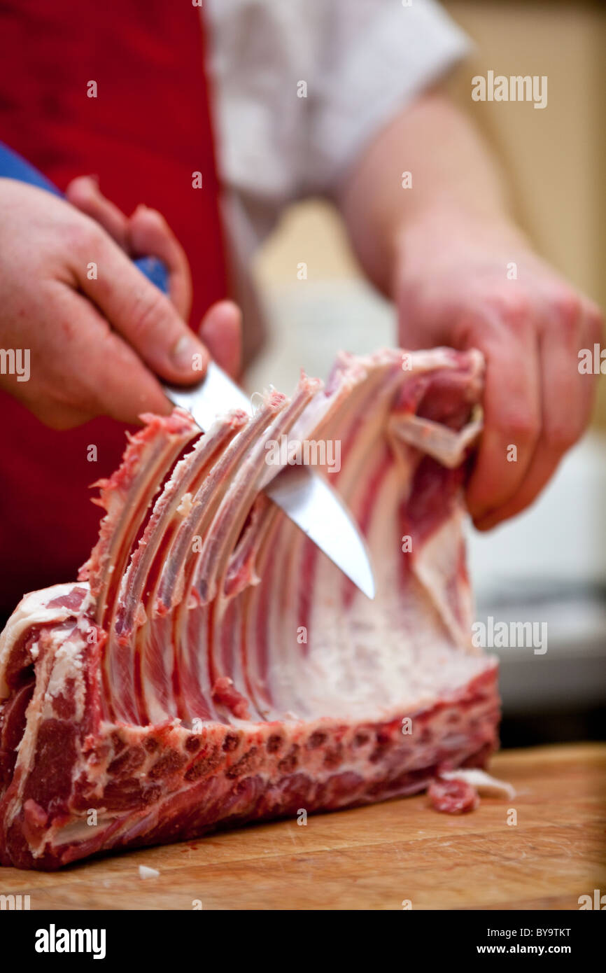 A butcher carving up a piece of lamb Stock Photo - Alamy