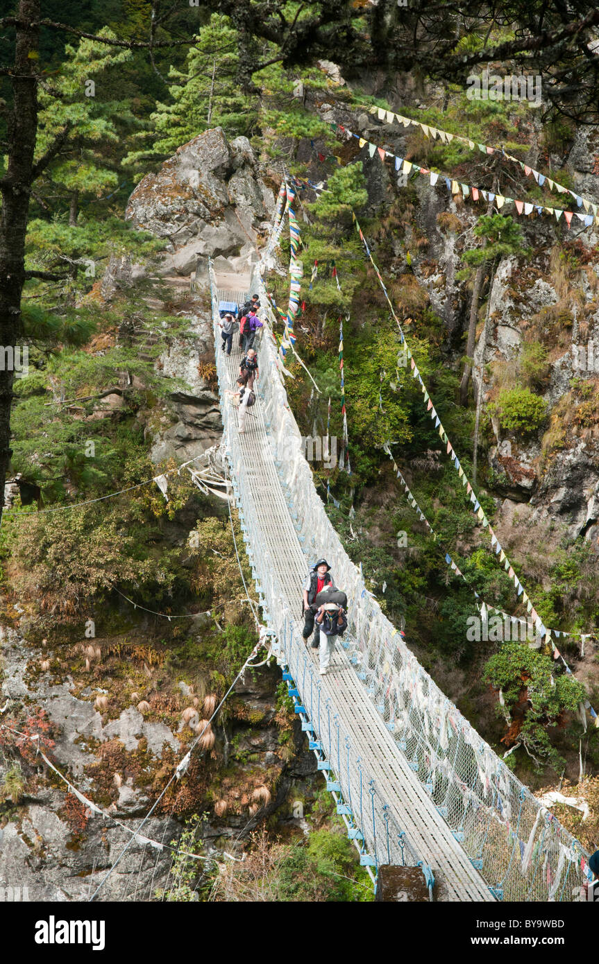 prayer flags blowing on suspension bridge crossing in the Everest ...
