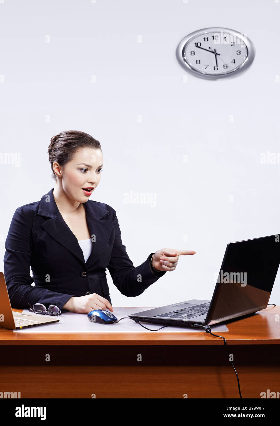 office portrait of beautiful young business woman pinting at laptop's ...