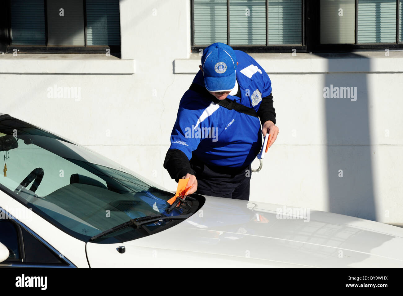 Parking police enforcer writes ticket for expired parking meter Stock ...