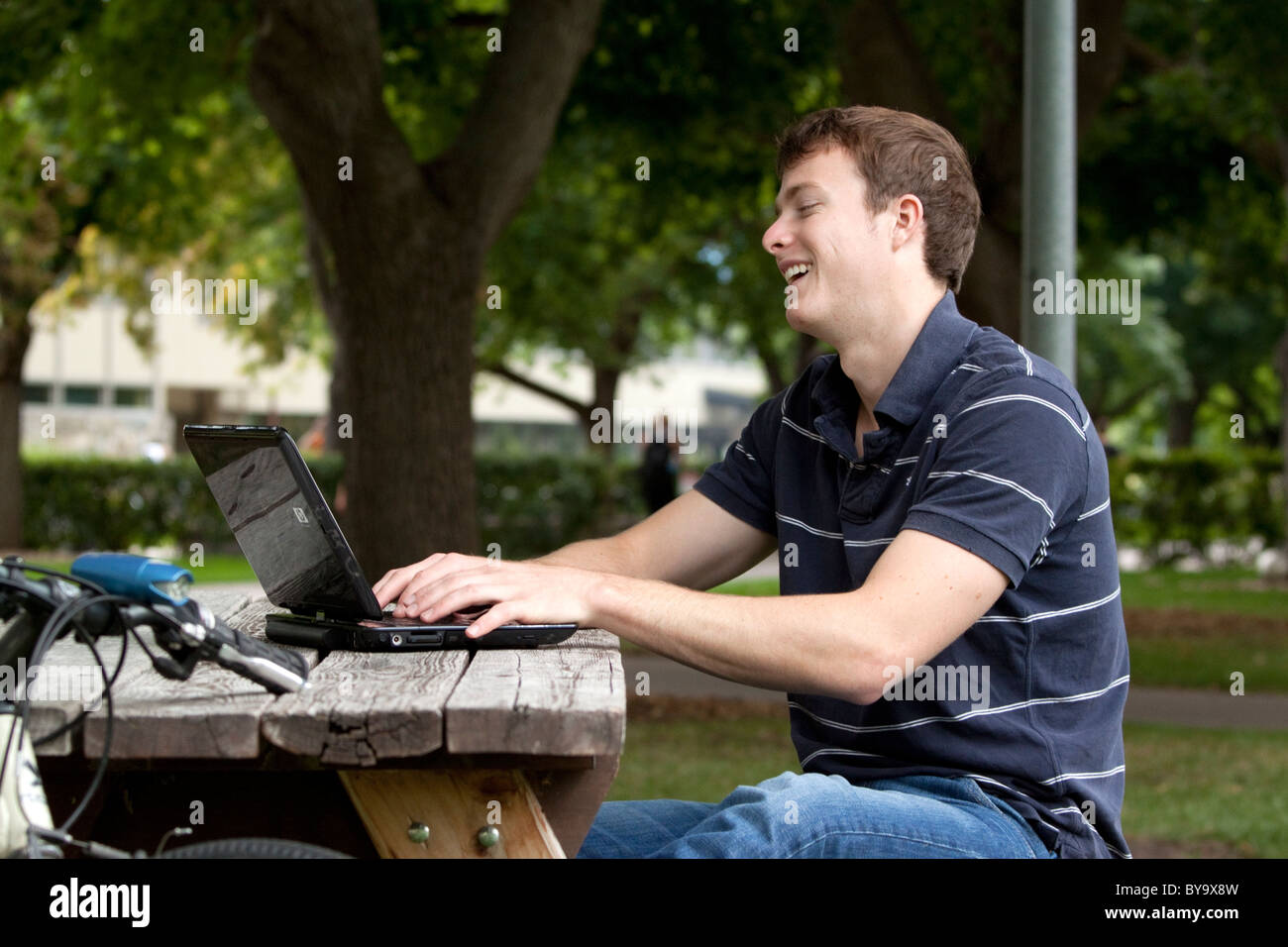 Young man reacting to what is on the screen of his laptop computer ...