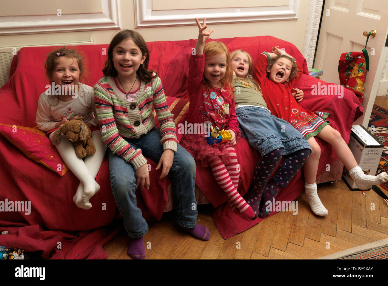 Young Sisters And Cousins Sitting On Sofa Together England Stock Photo ...