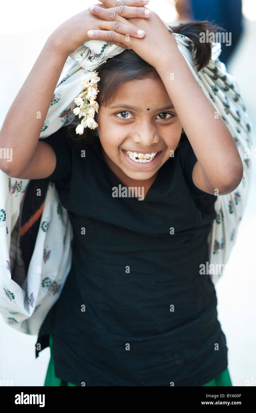 Smiling happy Indian village girl carry the laundry on her head. Andhra ...