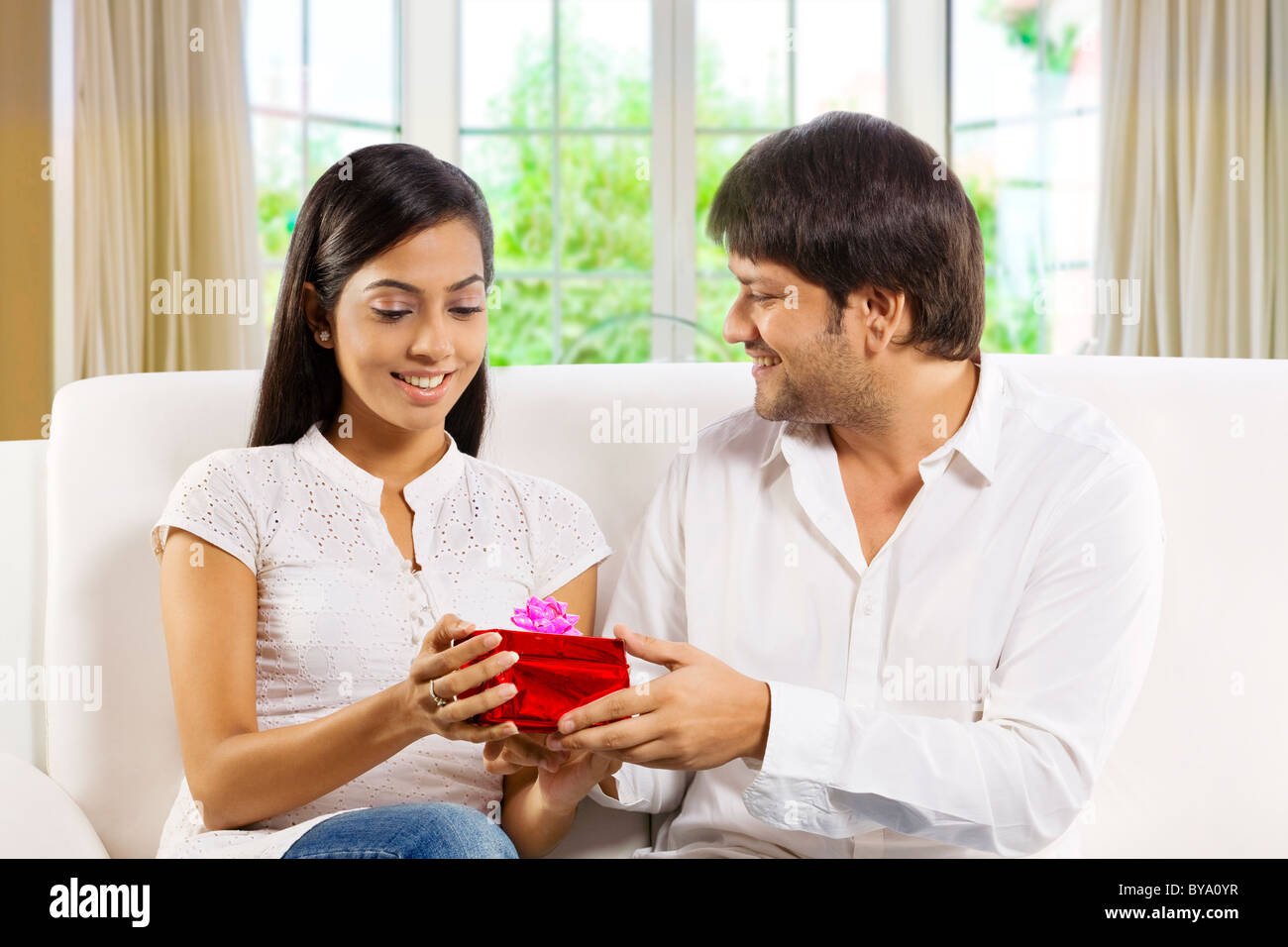 Man giving a gift to his wife Stock Photo - Alamy