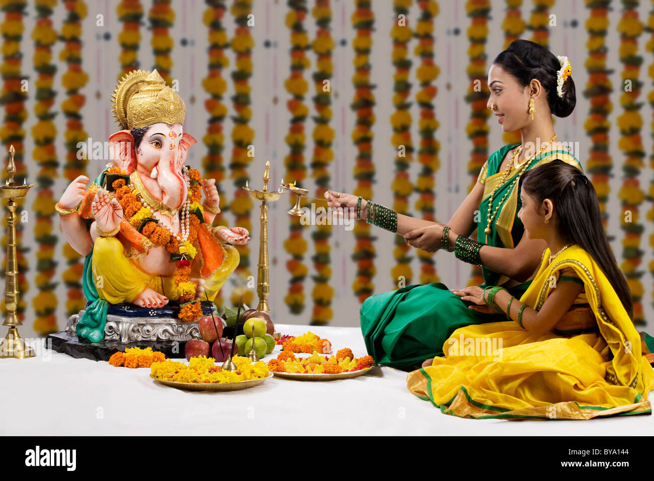 Mother and daughter performing a pooja Stock Photo - Alamy