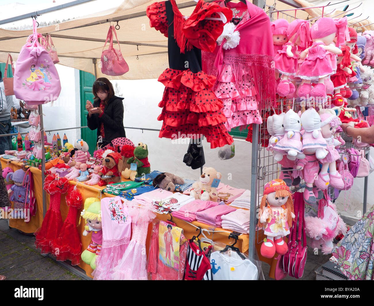 A stall with a colourful display of girls toys and red and pink ...