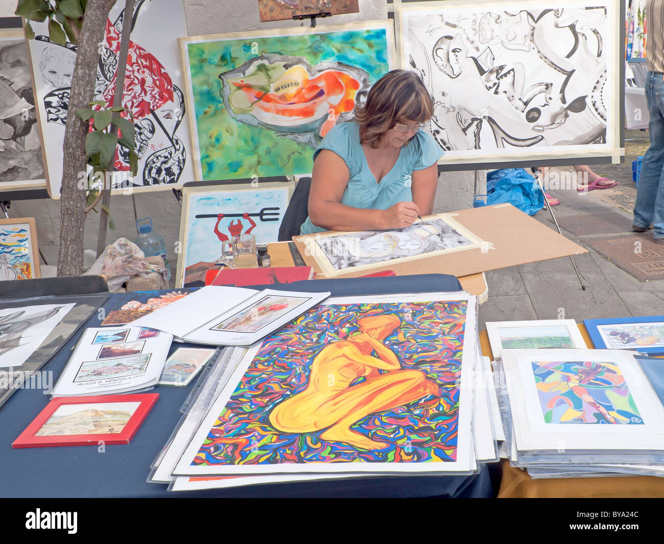 A local artist painting and selling her paintings at the weekly market ...