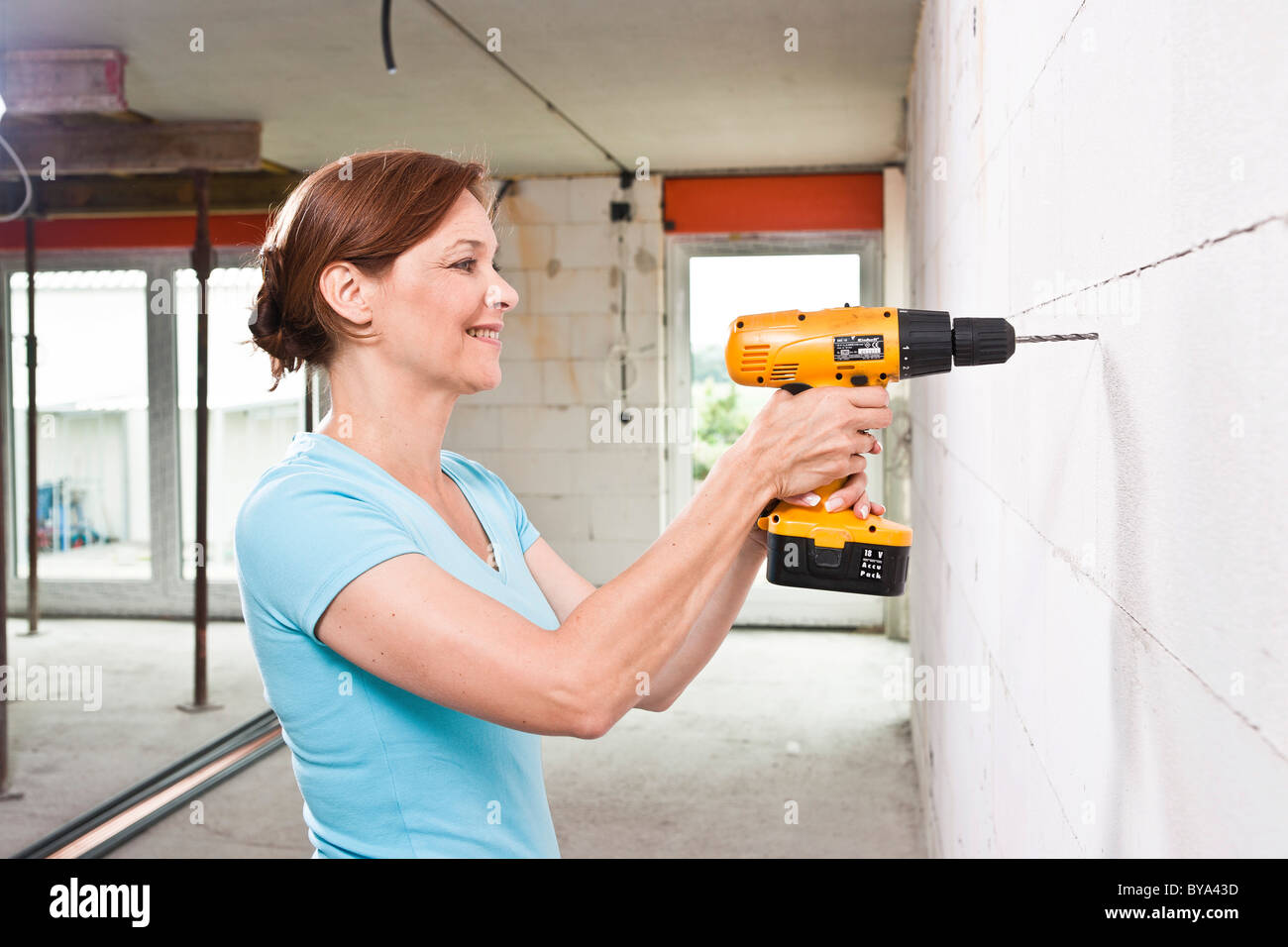 Smiling woman with cordless screwdriver Stock Photo - Alamy