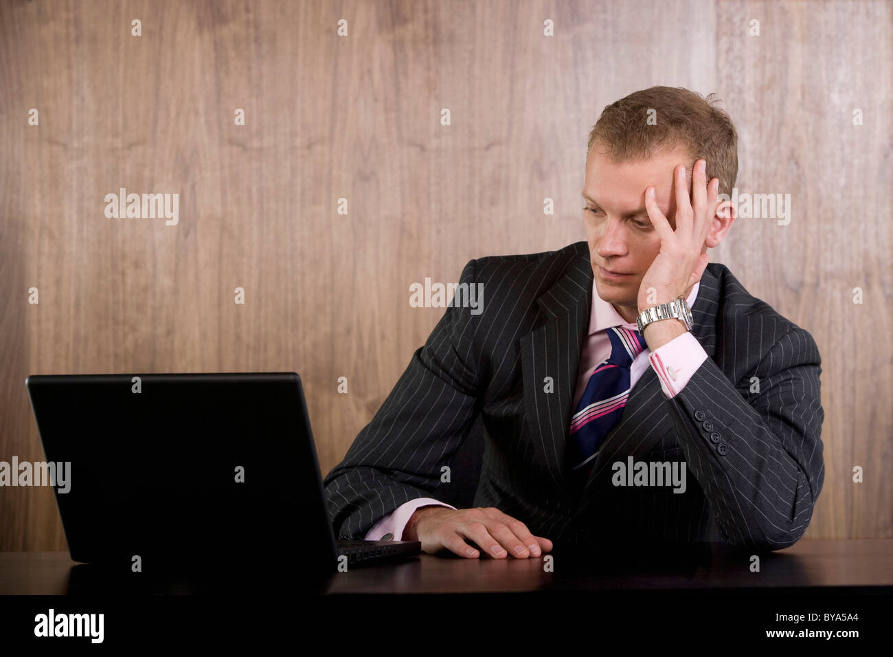 Unhappy business man looking at computer Stock Photo - Alamy
