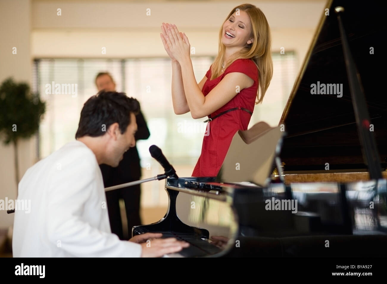 Piano player and singing girl Stock Photo - Alamy