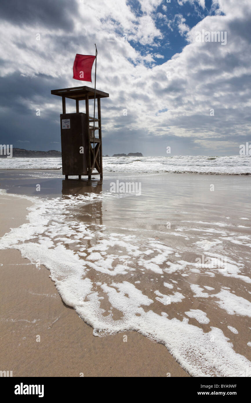 Lifeguard watch tower on the Playa Torá beach with red flag and ...