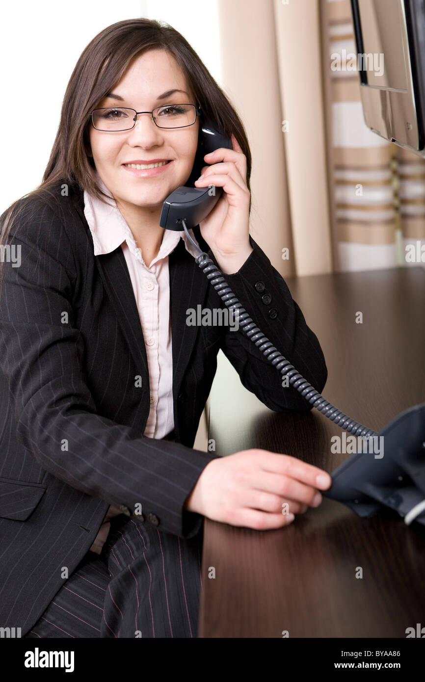 young adult woman at reception desk Stock Photo - Alamy