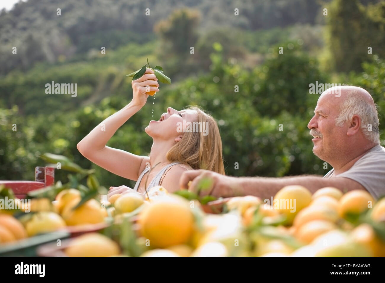 Girl squashing an orange Stock Photo - Alamy