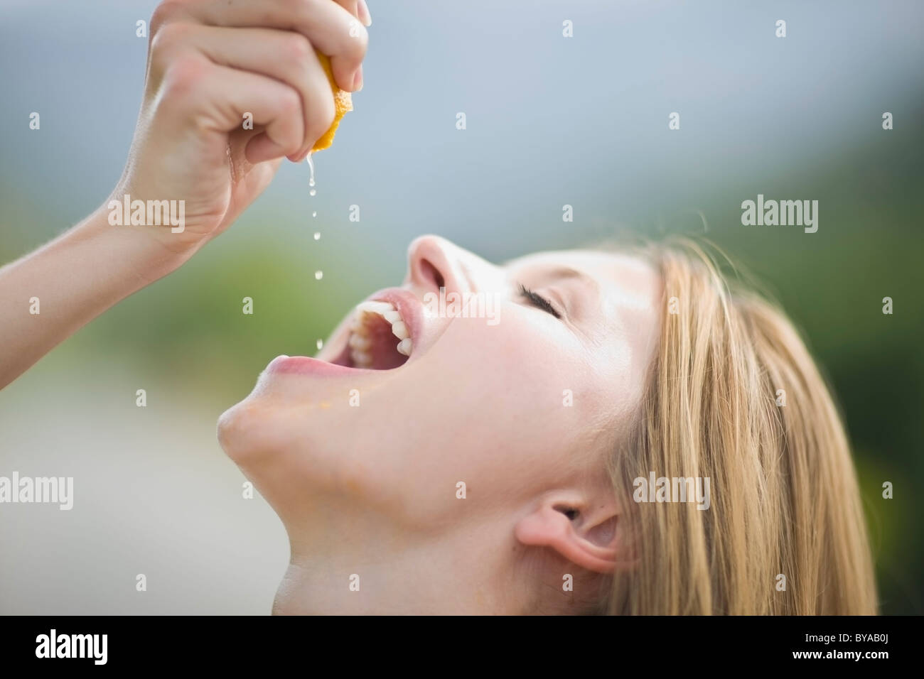 Girl squashing orange Stock Photo - Alamy