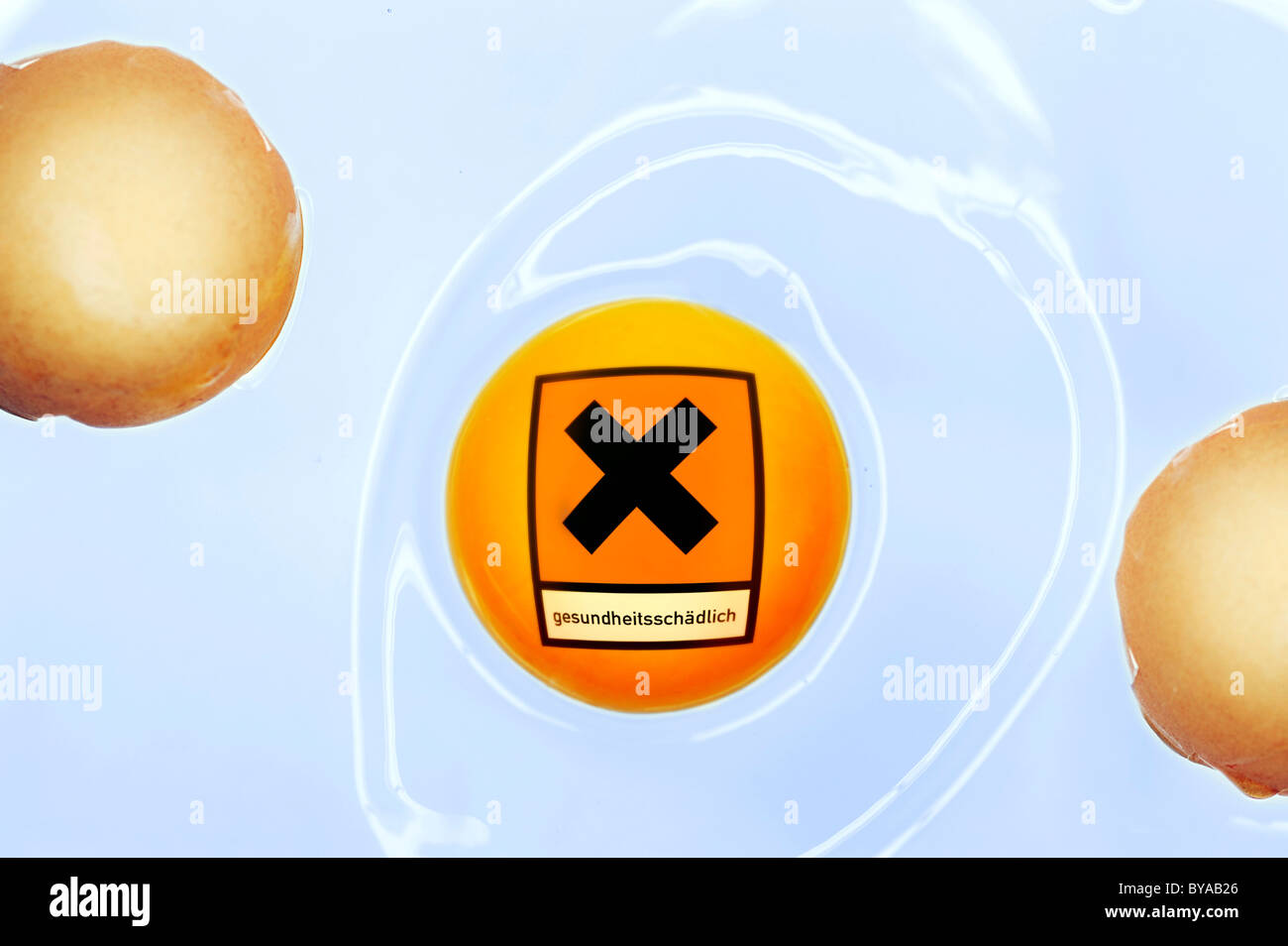 Cracked egg with a warning sign in the yolk, symbolic image for dioxin ...