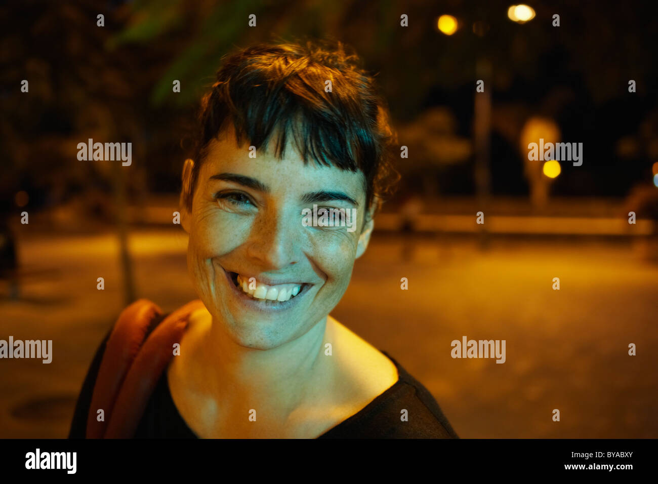 Woman by night smiling to camera Stock Photo - Alamy