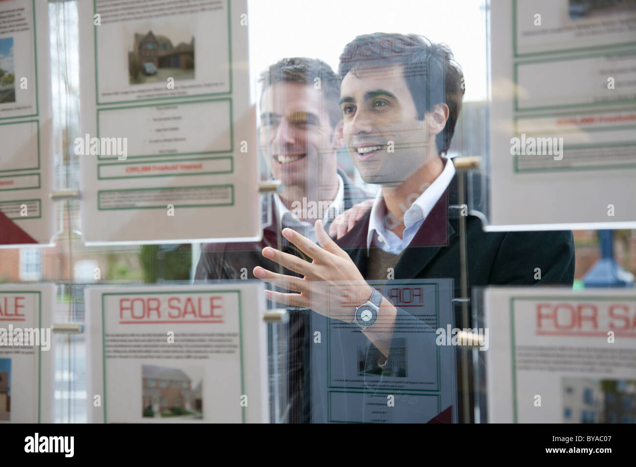Couple looking into estate agents window Stock Photo - Alamy