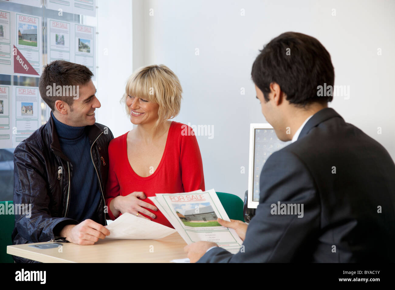 Couple visiting estate agents office Stock Photo - Alamy