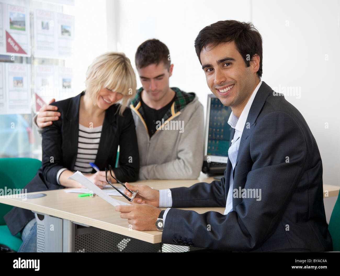 Couple visiting estate agents office Stock Photo - Alamy