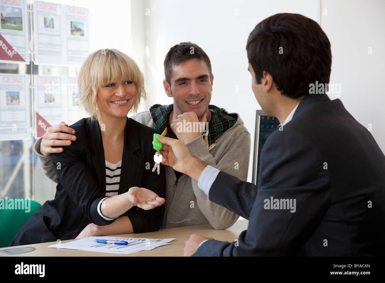 Couple visiting estate agents office Stock Photo - Alamy