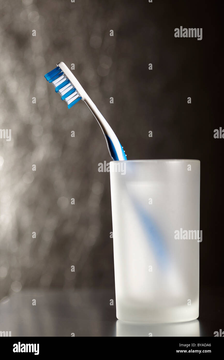 Blue and white toothbrush in a water glass, silver-coloured Stock Photo ...