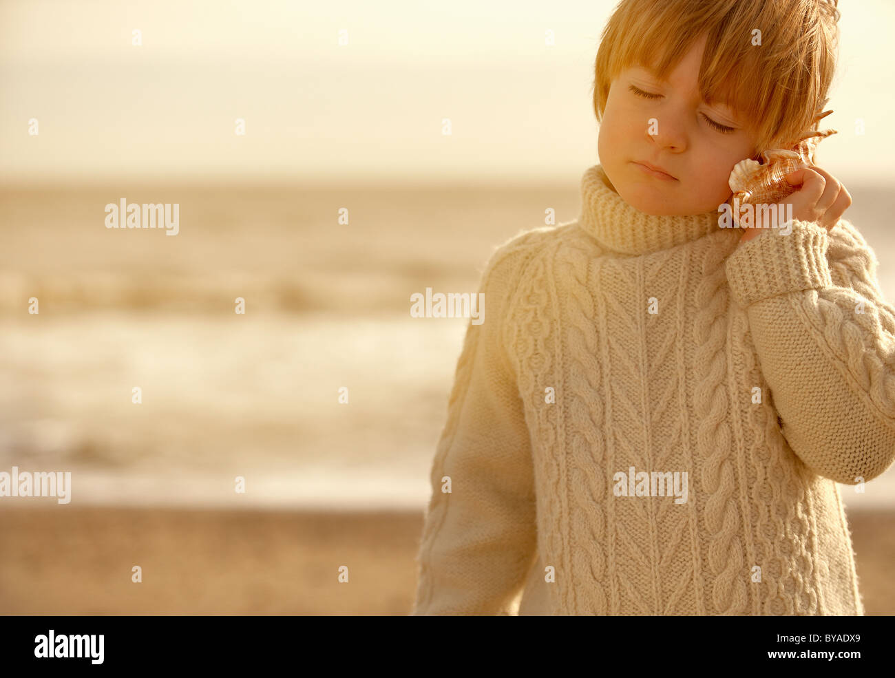 Boy holding seashell hi-res stock photography and images - Alamy