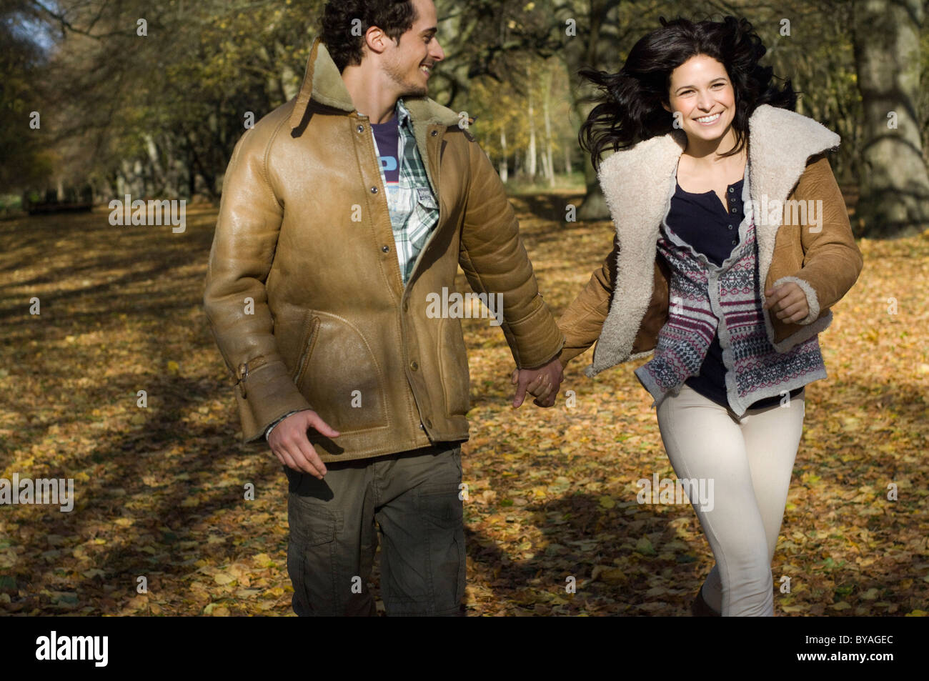 Couple running hand in hand Stock Photo - Alamy