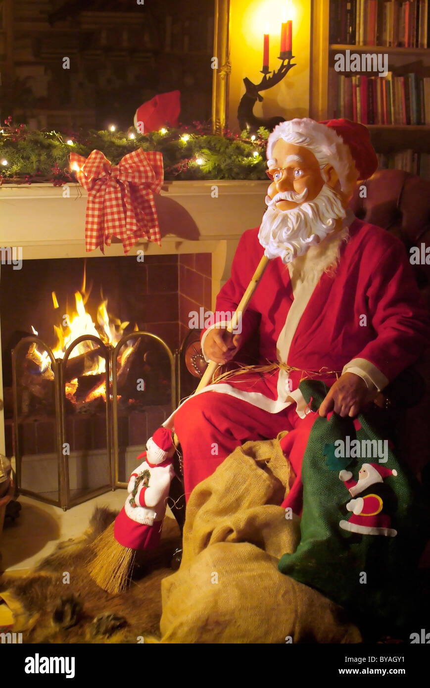 Santa Claus figure sitting in front of fireplace Stock Photo - Alamy