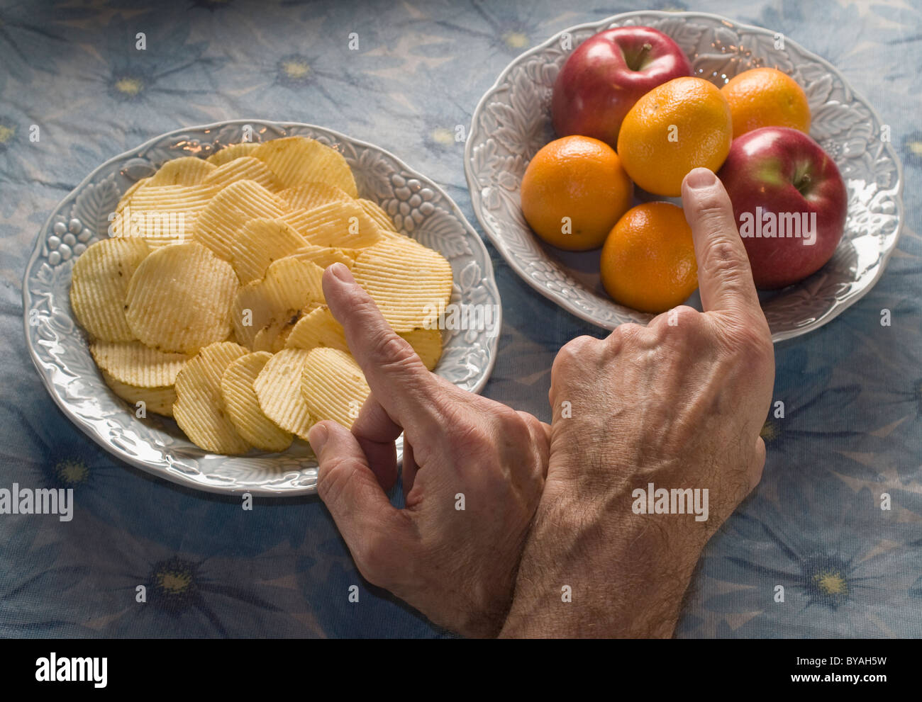 man pointing to bowls of potato chips and fruit Stock Photo - Alamy