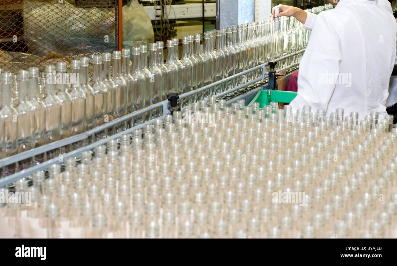 production of alcohol drinks - an operator monitors quality of empty ...