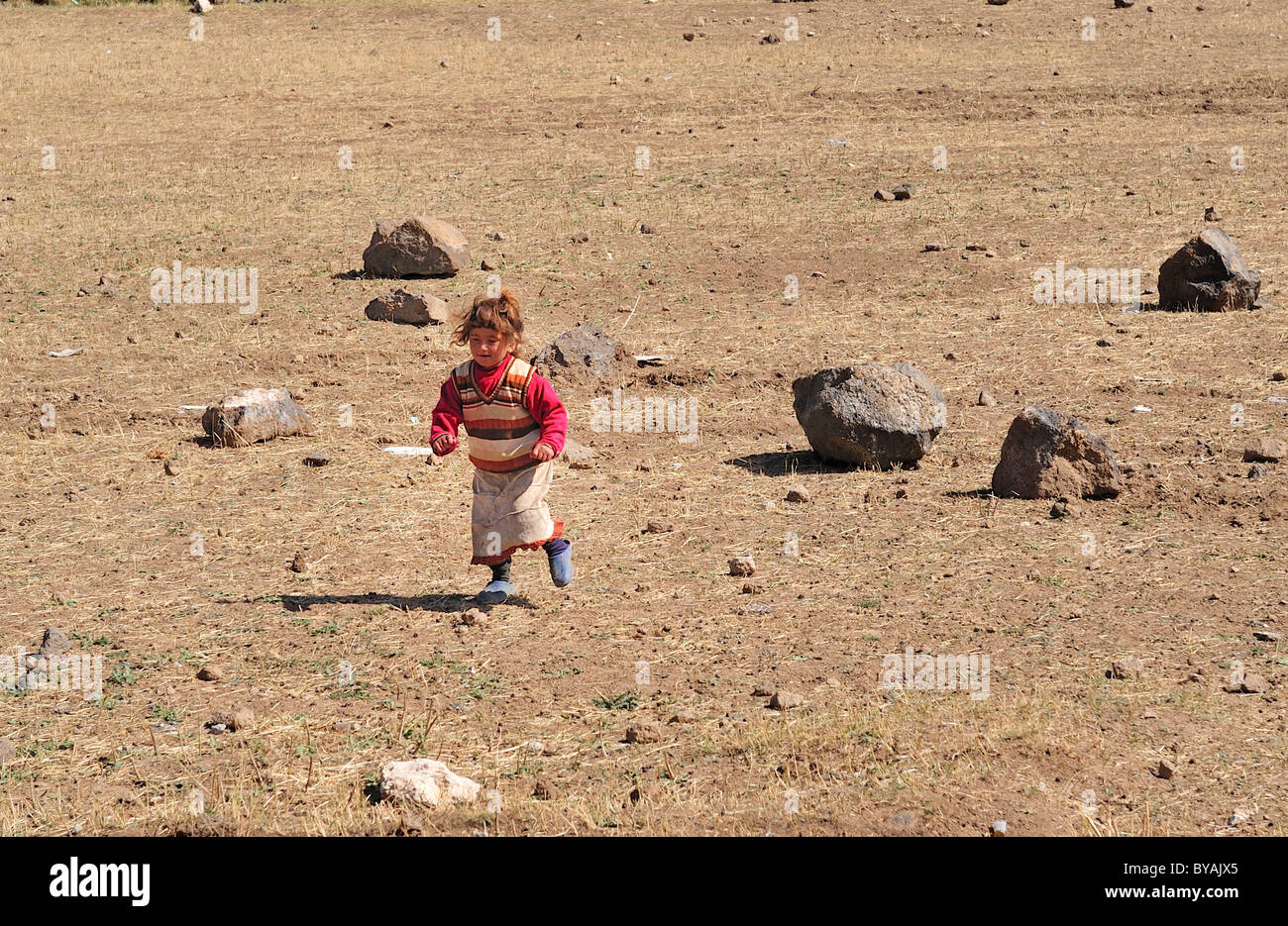 Village child running to see the tourists, near Tendürek Dagi, Turkey ...