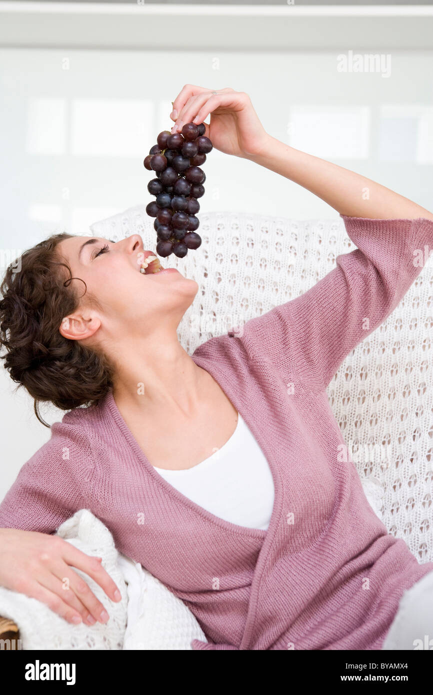Woman eating grapes Stock Photo - Alamy