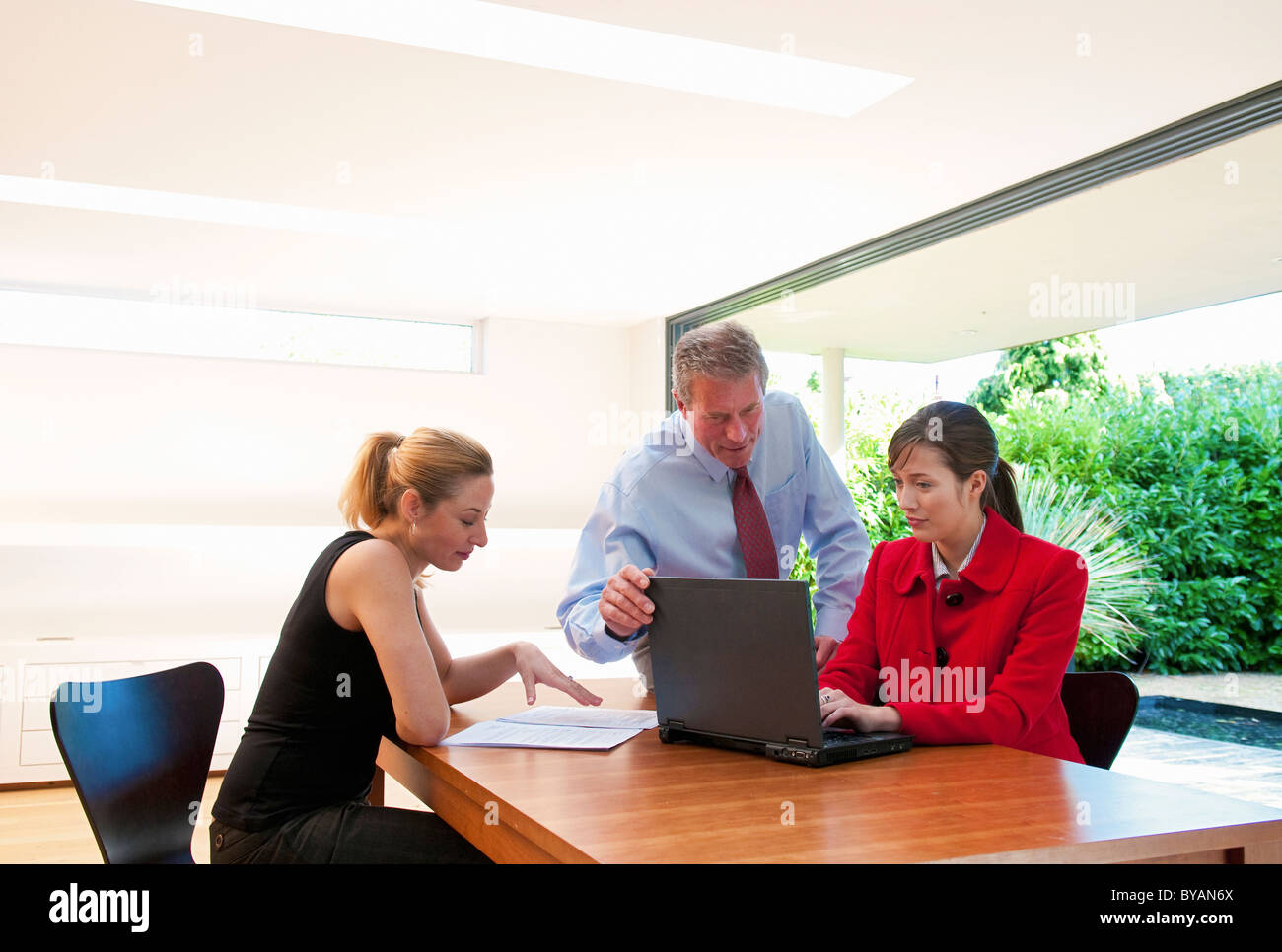 Three business people check data Stock Photo - Alamy