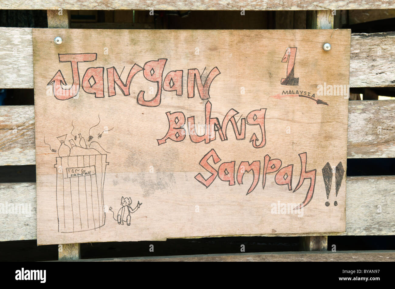 Homemade sign in Malay language telling people to put garbage in cans ...