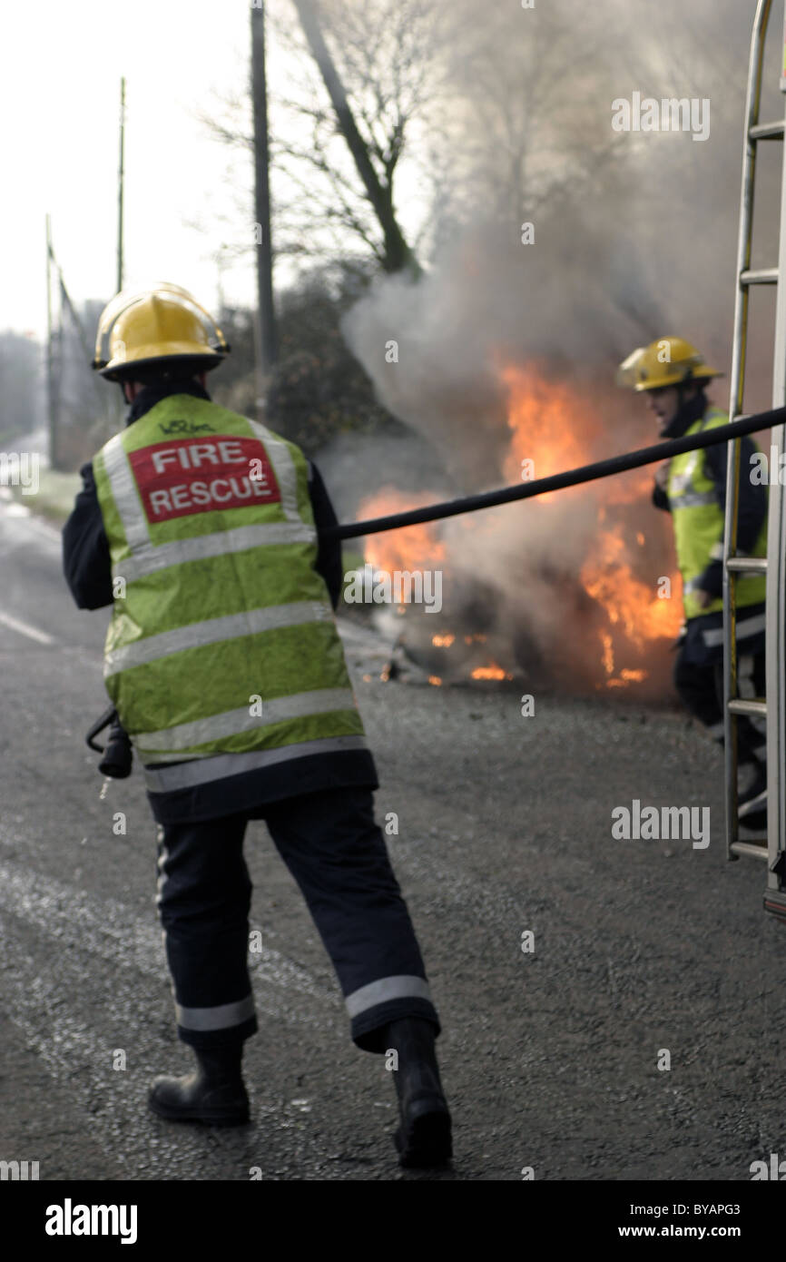 Firefighter approaches a car fire Stock Photo - Alamy