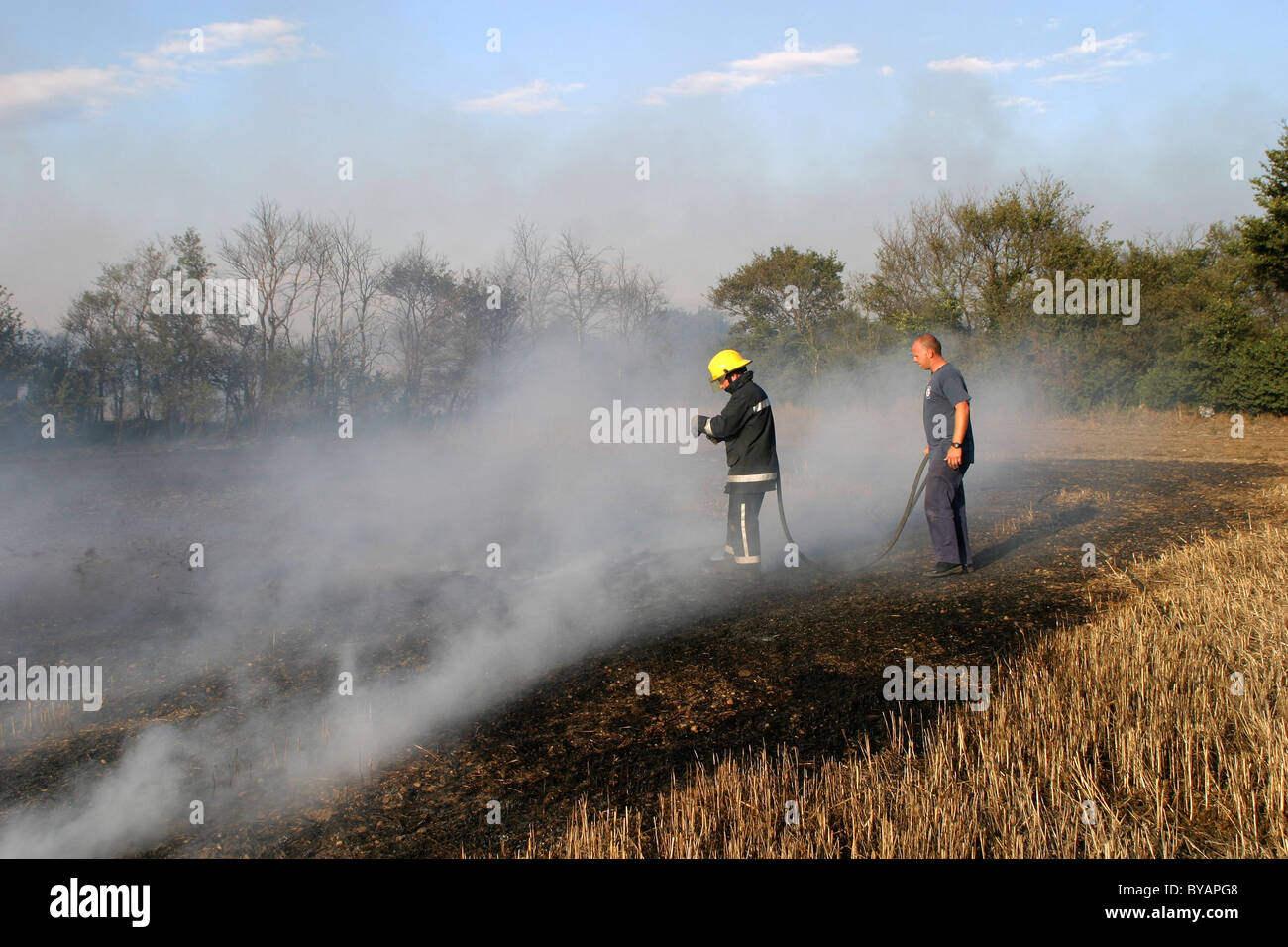 Firemen tackle a stubble fire in Essex Stock Photo - Alamy