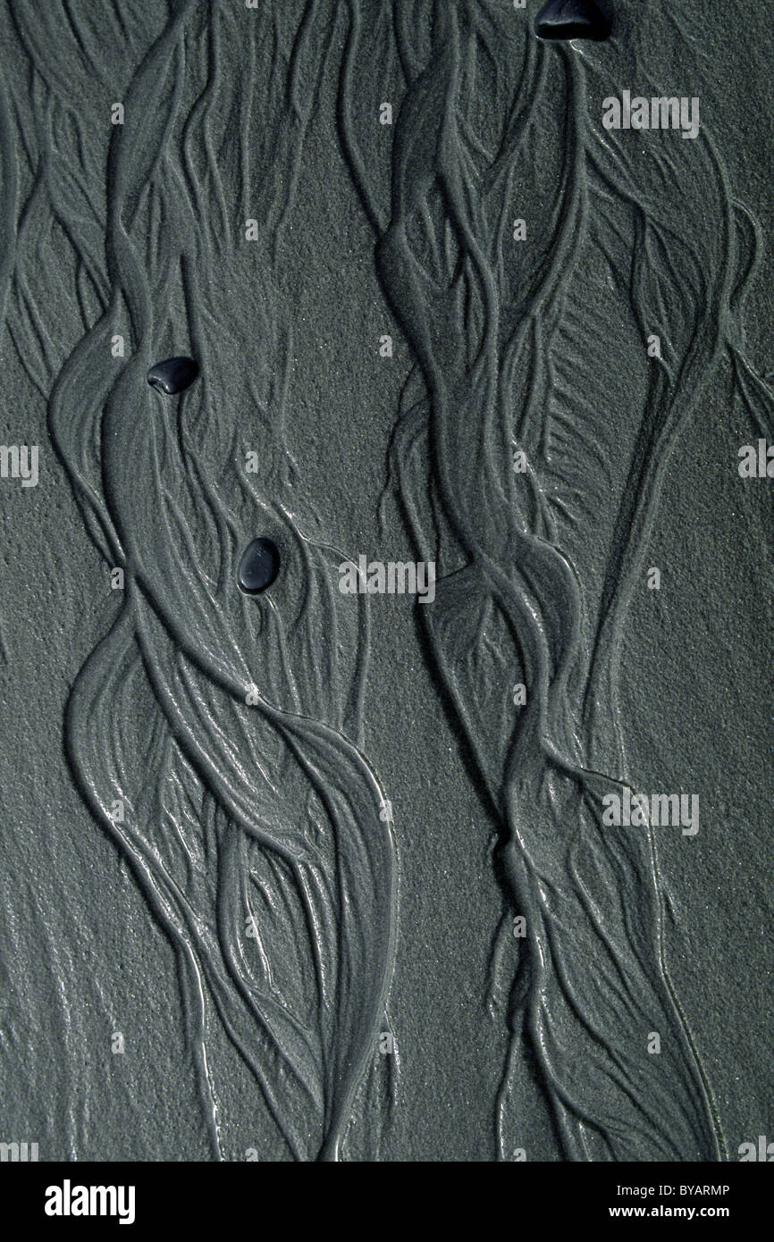 Rivulets in sand with pebbles on a beach Stock Photo - Alamy
